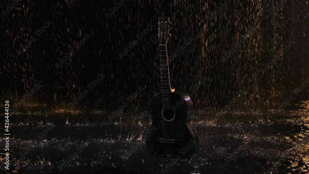 Vidéo Stock Detailed footage of a wooden acoustic guitar in the rain ...