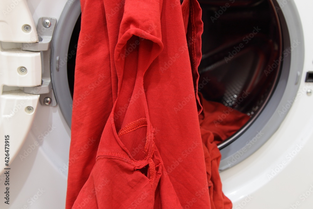 Torn laundry on basket of an automatic washing machine background ...