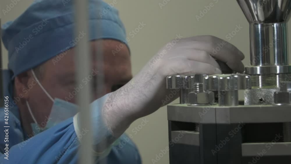 Medical technician is rotating the screw of the machine. Checking the ...