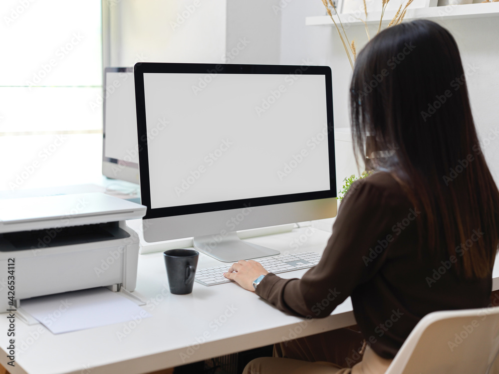 Back view of female office worker working with computer device in ...