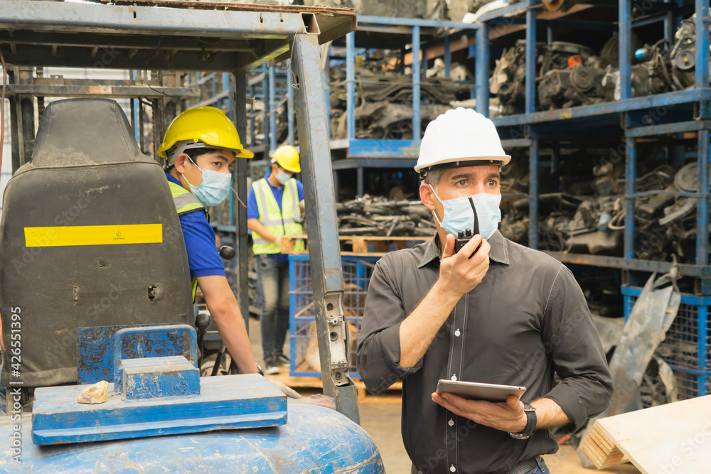 Men work together, wear safety facemask, use walkie-talkie. Caucasian ...