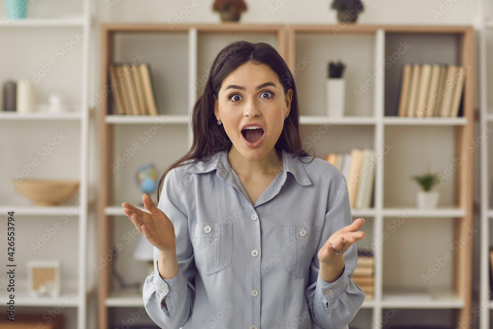 Foto de Portrait of funny surprised woman talking at home on video call ...
