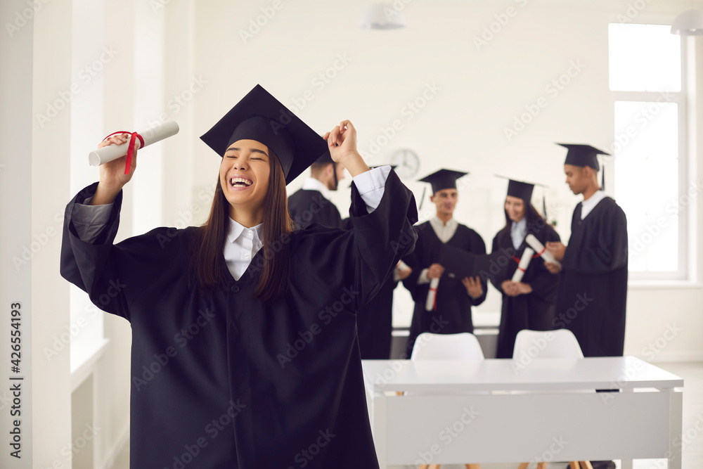 Laughing cheerful asian girl student university graduate in mantle and ...