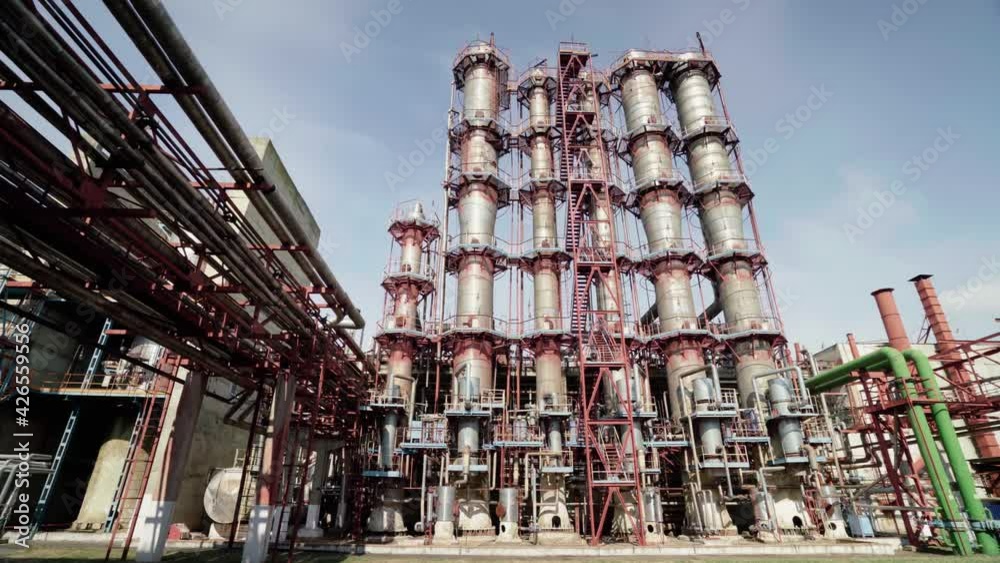 A huge oil refinery with metal structures, pipes and distillation of ...
