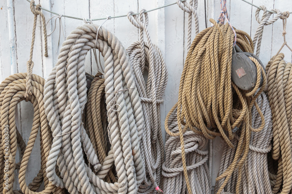rope and mooring lines hanging from a wooden wall Stock Photo | Adobe Stock