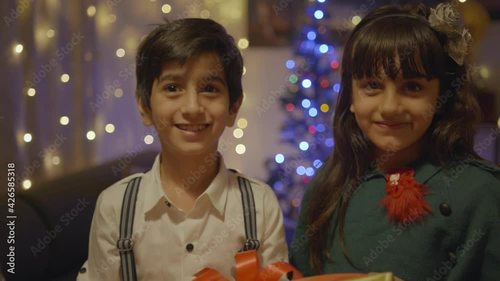 Two well dressed adorable young kids are smiling and receiving their ...
