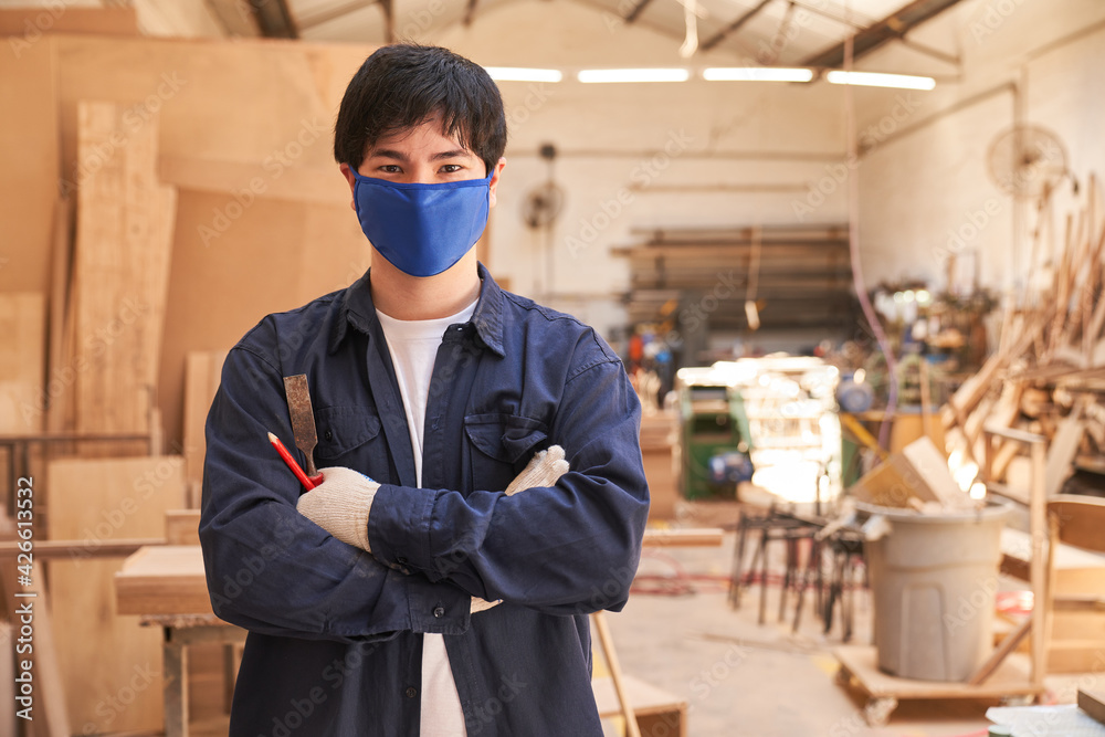 Carpenter apprentice with face mask because of Covid-19 Stock Photo ...