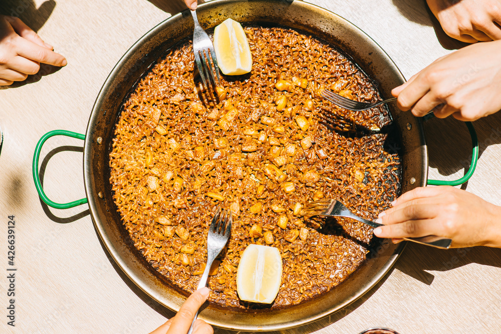 Time to eat paella. Several hands with cutlery start eating homemade ...