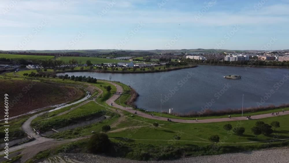 A park in a green area near the lake during the daytime shot in 4K ...