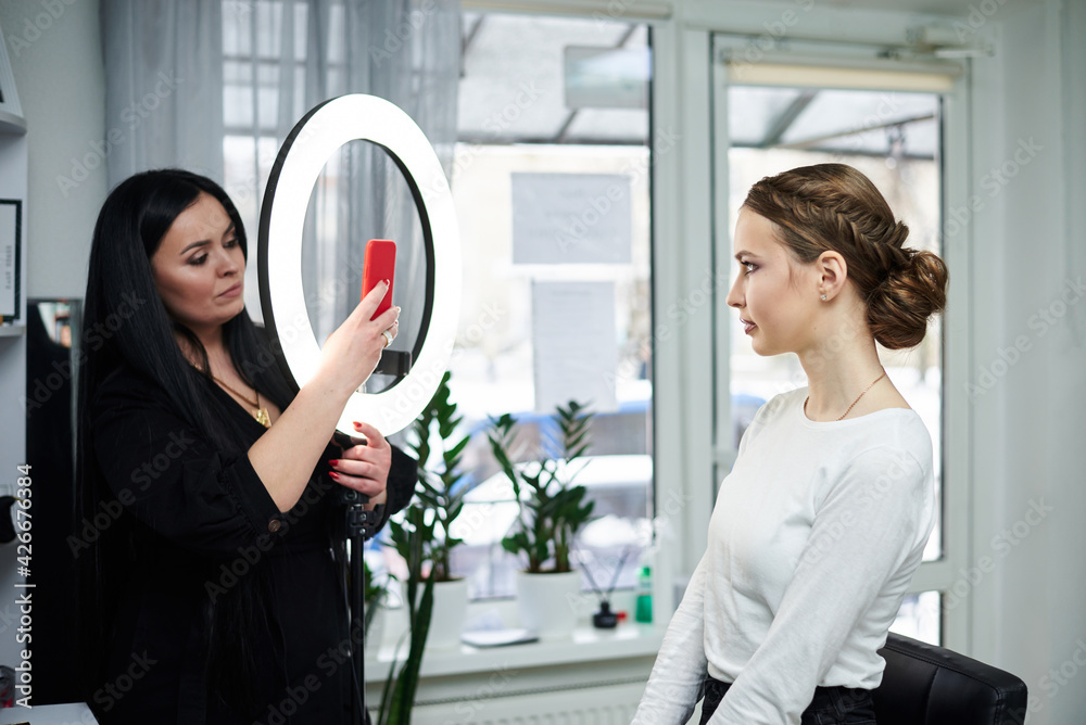 Professional make-up artist taking picture of work result with her ...