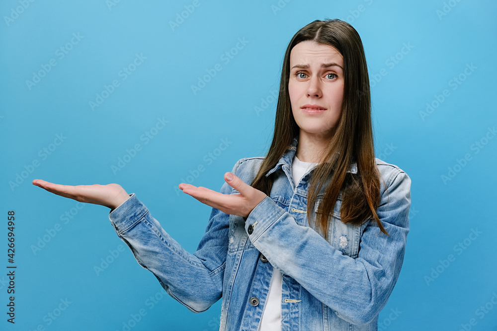 Young displeased woman looking camera pointing showing fingers hands on ...