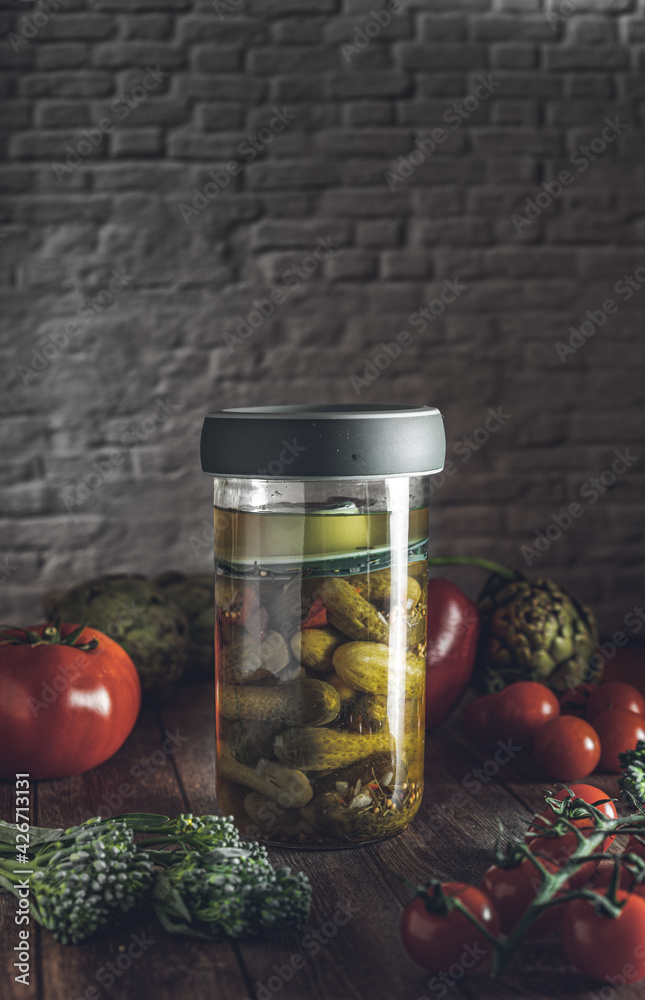 dark food photography of a press jar with homemade fermented pickles ...