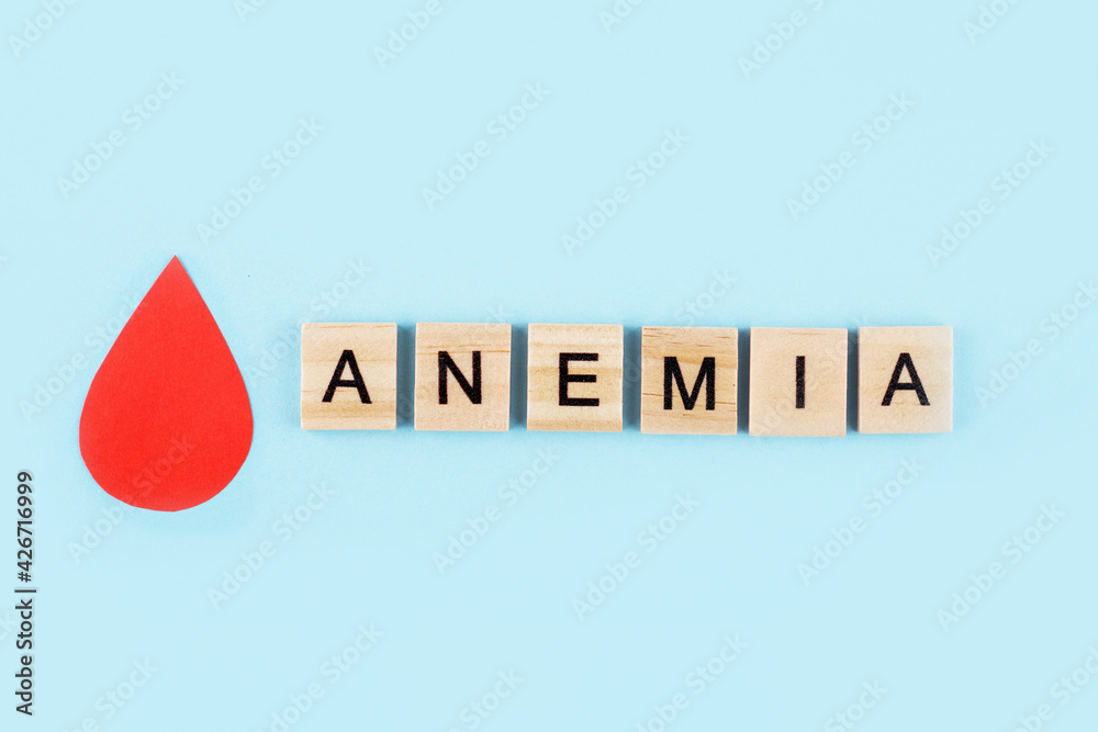 Anemia - words from wooden blocks with letters, a drop of blood ...