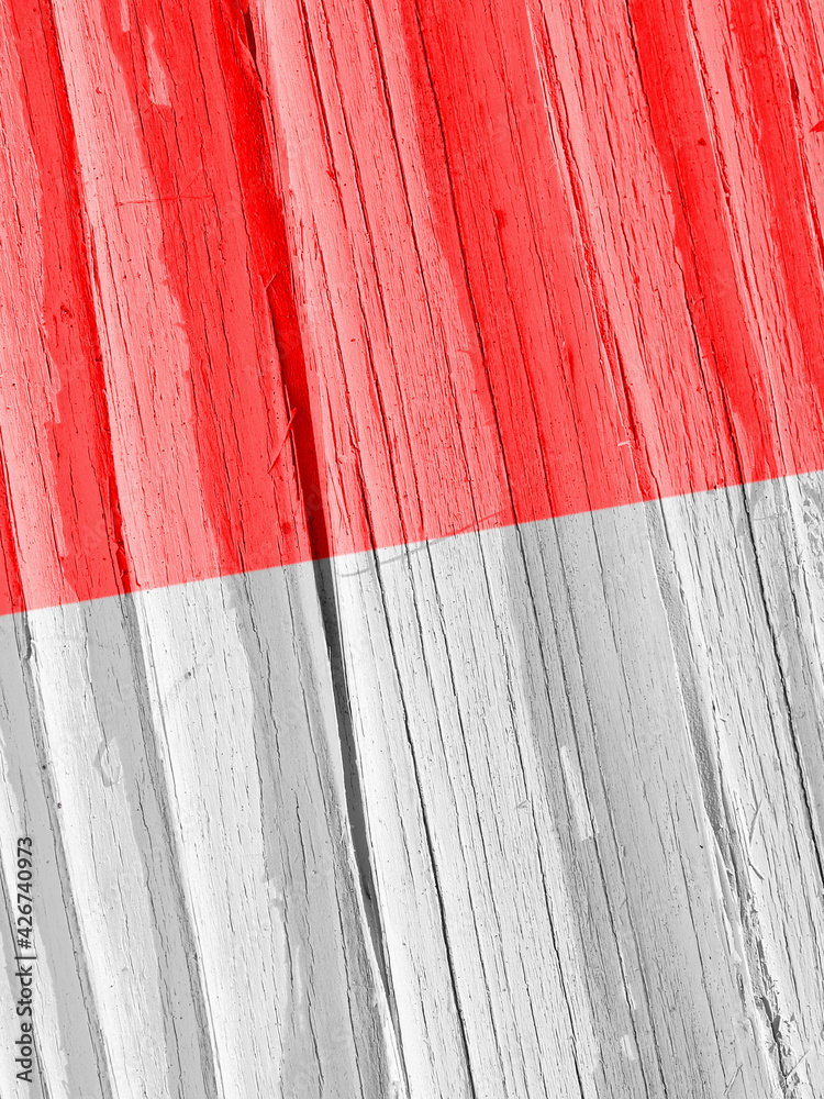 The flag of Indonesia on dry wooden surface, cracked with age. Vertical ...