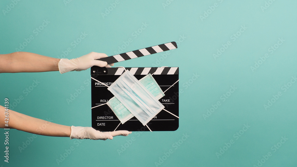 Hand wear medical gloves and hold black Clapperboard or movie slate ...