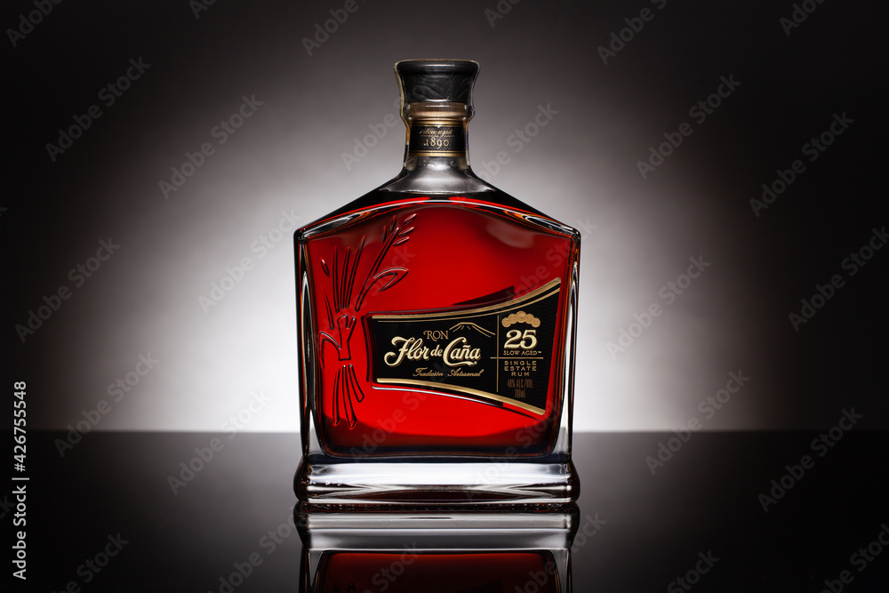 Flor de Cana Centenario 25 Y.O. on the black glass table. Stock Photo ...