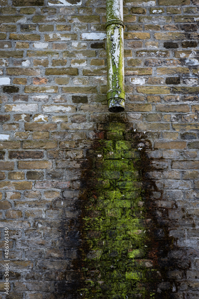 Weathered rain gutter pipe on the old, damaged brick wall - The beauty ...