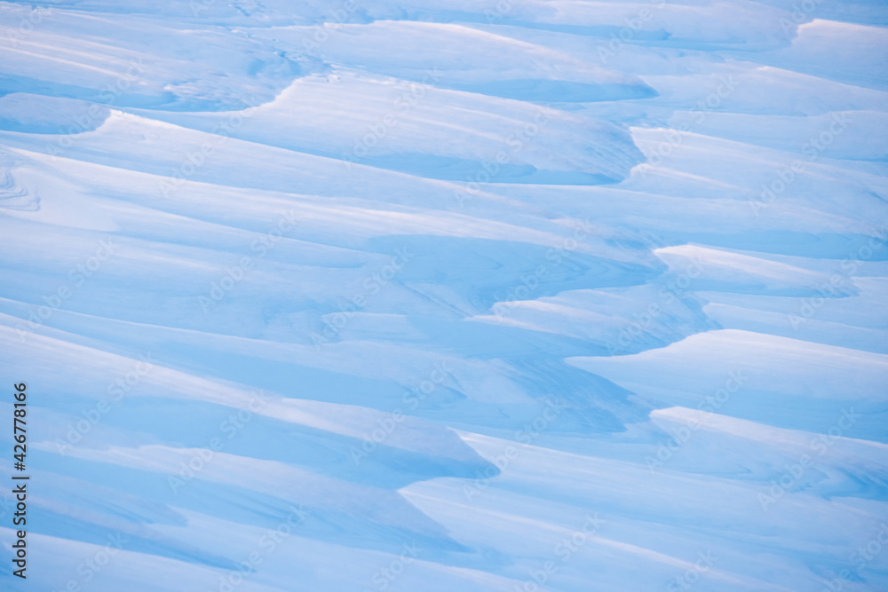 Fotka „Snow texture. Wind sculpted patterns on snow surface. Wind in ...