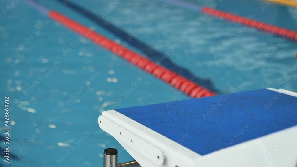 close-up of the legs and arms of a teenage swimmer taking off from the ...