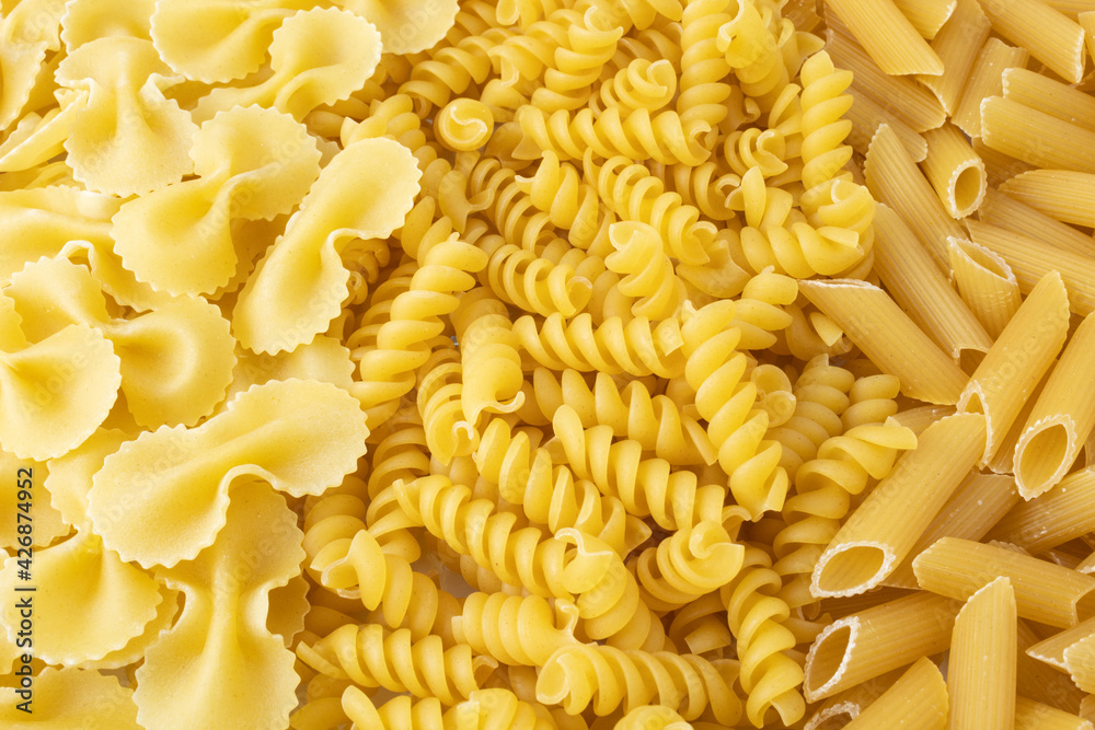 Texture with raw fusilli, farfalle and penne pasta. Three different ...