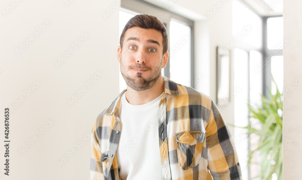 handsome man with a goofy, crazy, surprised expression, puffing cheeks ...