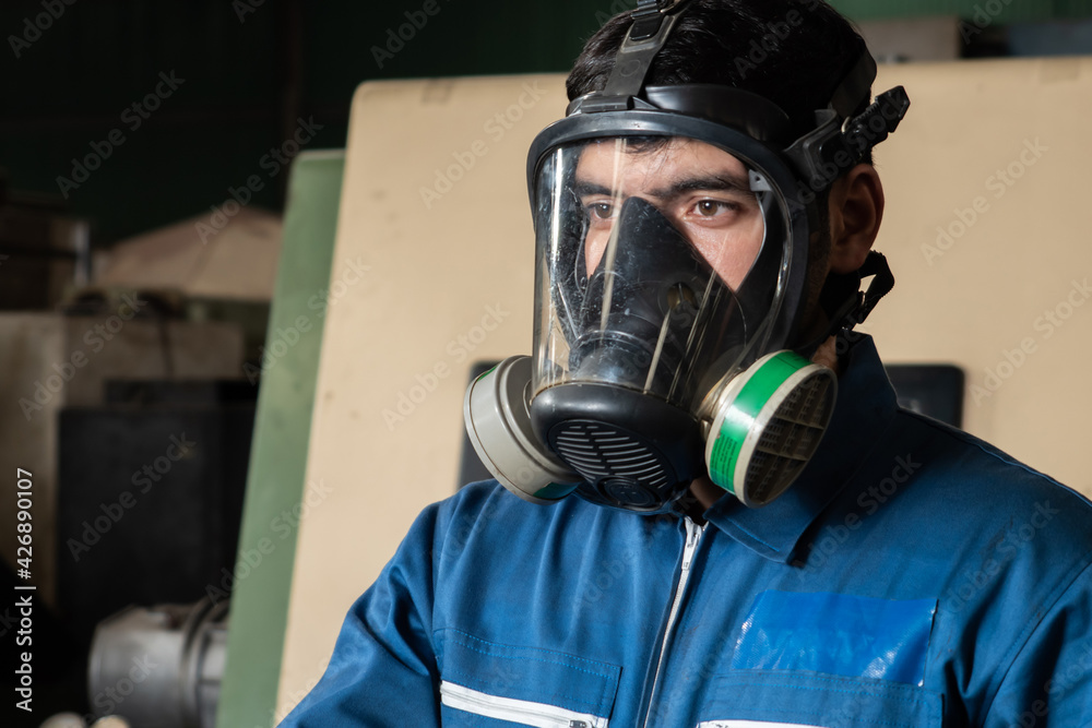 Skillful worker wears gas mask in the factory . Industrial people and ...