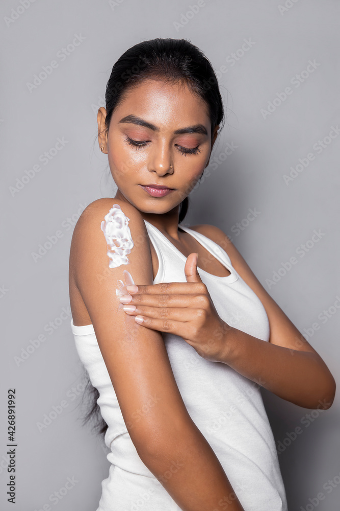 Indian girl model applying a woman applying a lotion to her hand ...