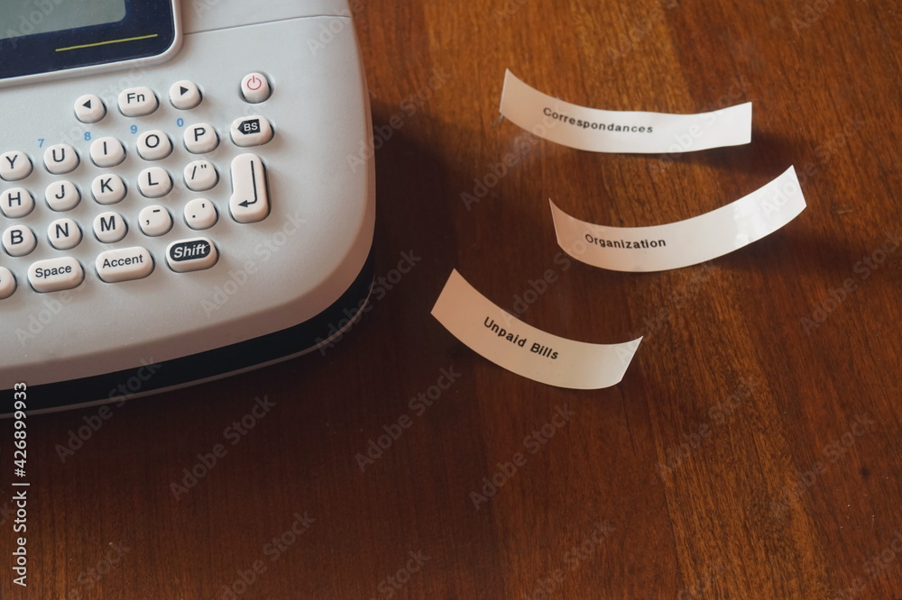 Foto de Label Maker with Thtee White Labels on Maple Wood Desk do Stock ...