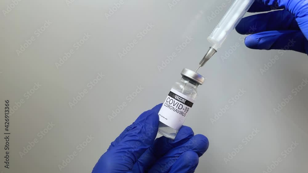 Close-up of doctor hands loading vaccine from glass vial, covid-19 ...