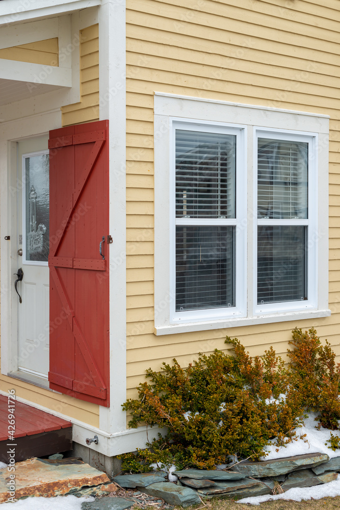 The exterior wall of a yellow wood clapboard heritage house. The door ...