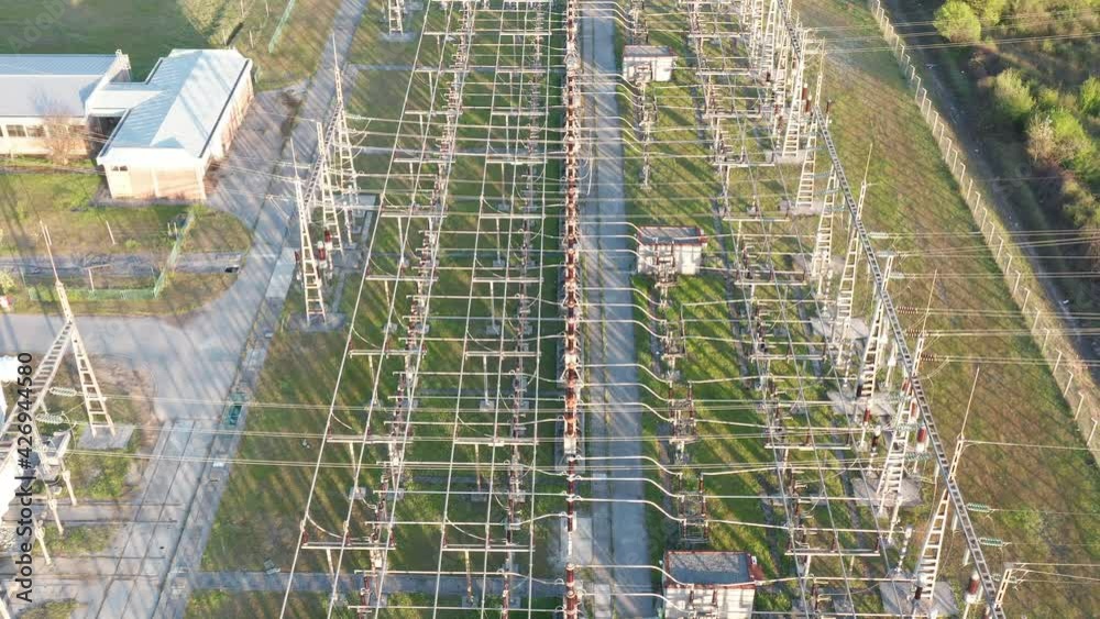 Electrical substation: transformers and grid of pylons, lines and wires ...