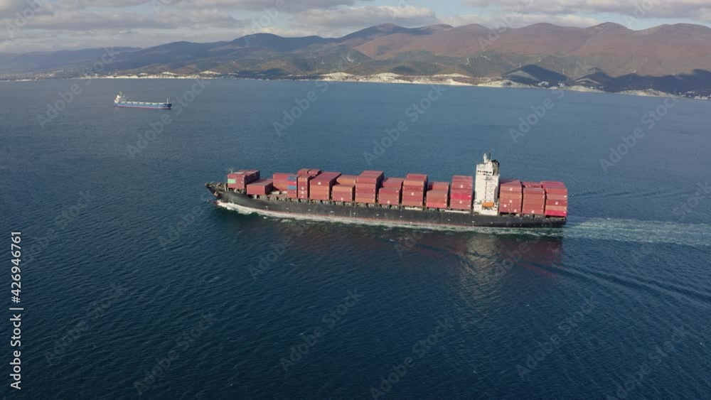 Ultra large container ship sailing at sea, aerial side view footage ...