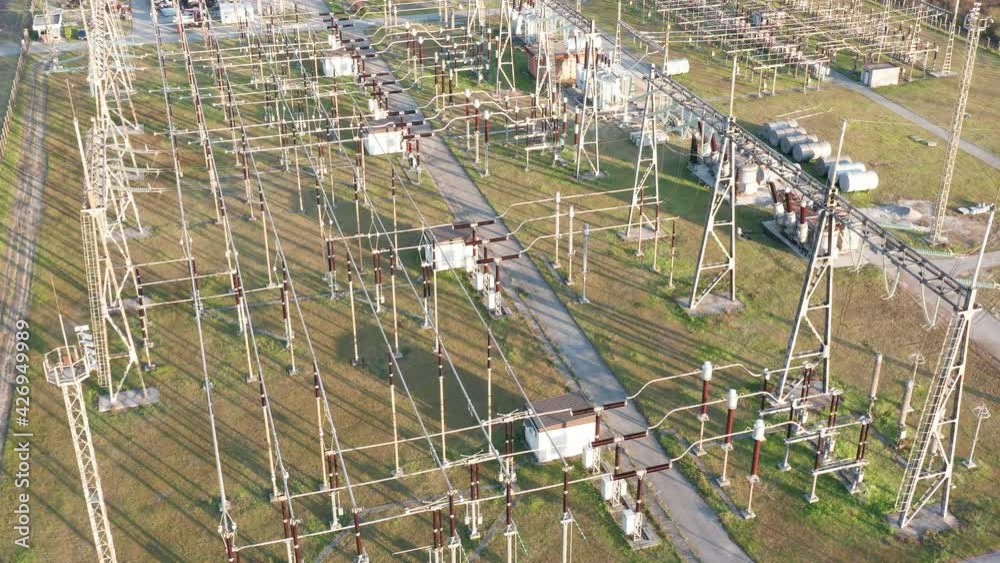 Electrical substation: transformers and grid of pylons, lines and wires ...