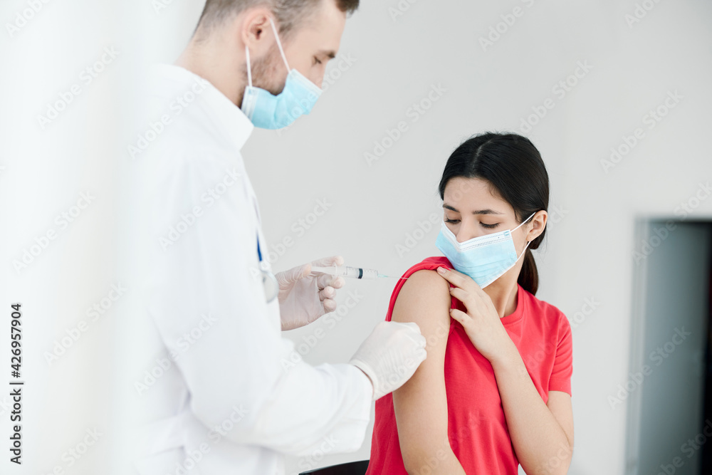 male doctor in a white coat and a syringe in his hands an injection in ...