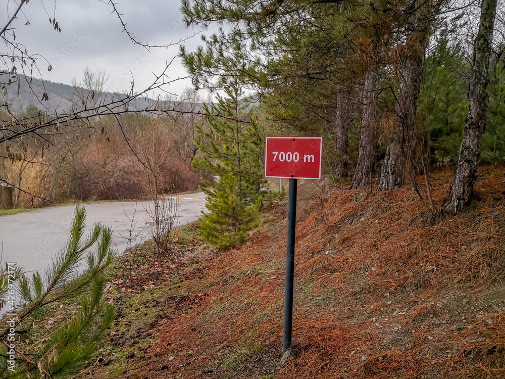 Signboard showing distance for walking in the forest.The red sign says ...