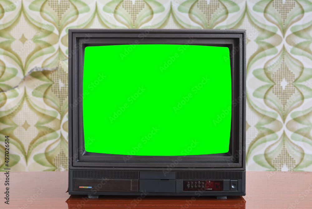 Antique TV with green screen on an antique wooden cabinet, old design ...