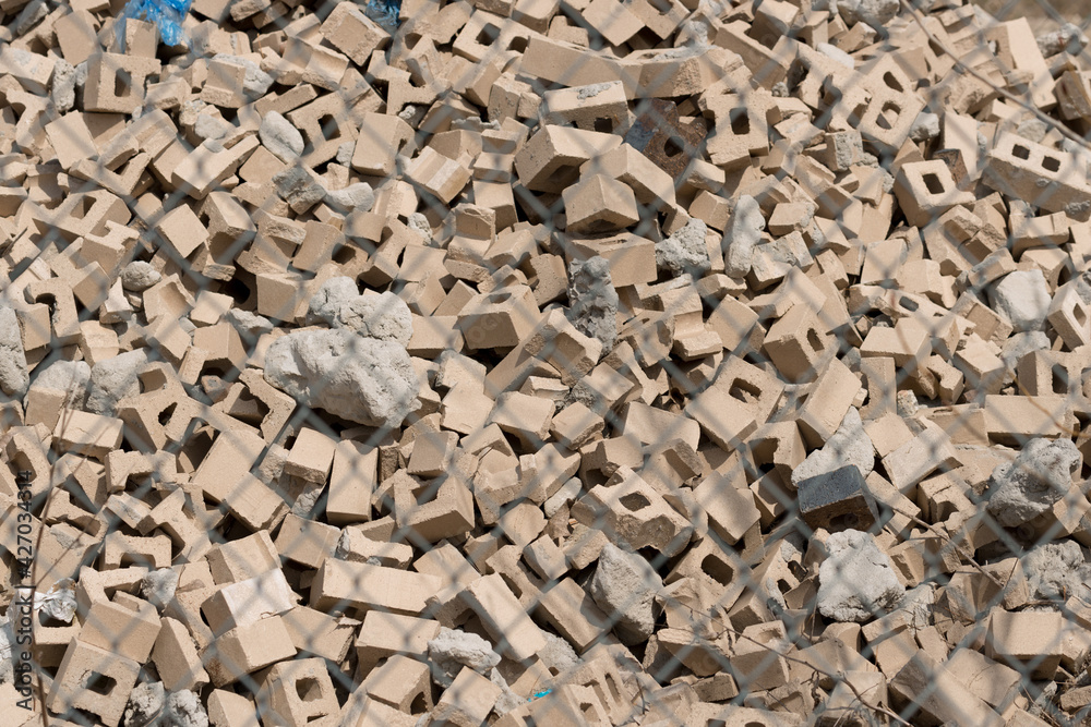 pile of broken bricks behind a chain link fence Stock Photo | Adobe Stock