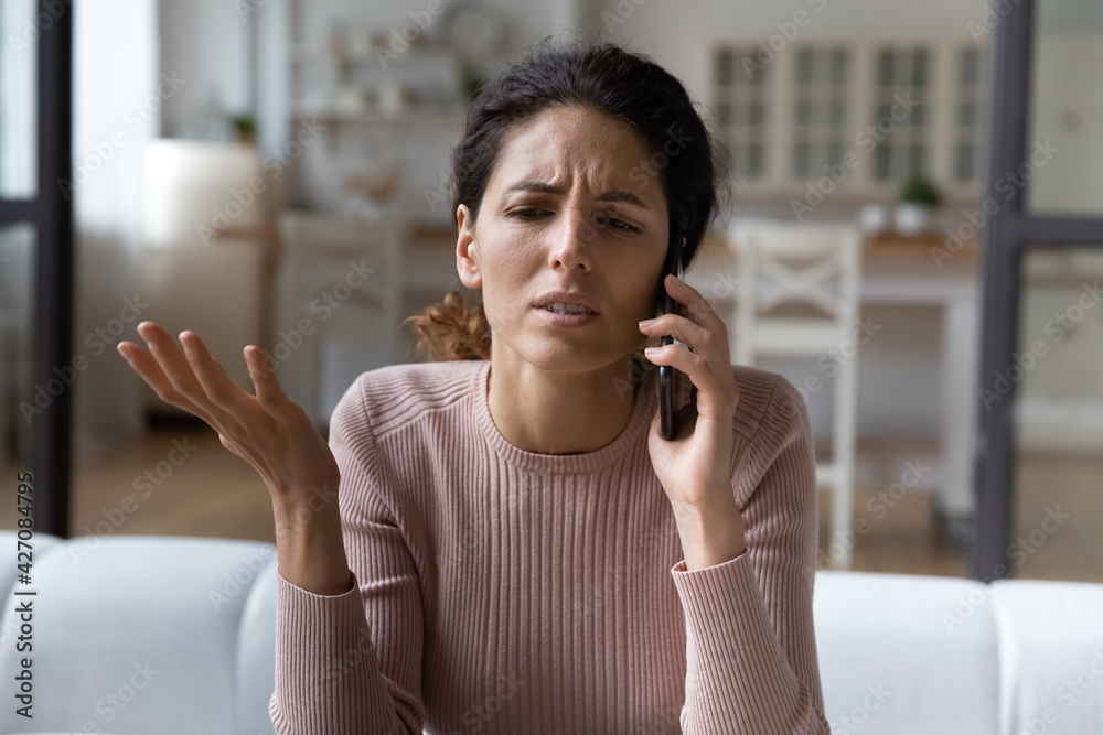 Talking about problems. Sad young hispanic female hold phone to ear ...