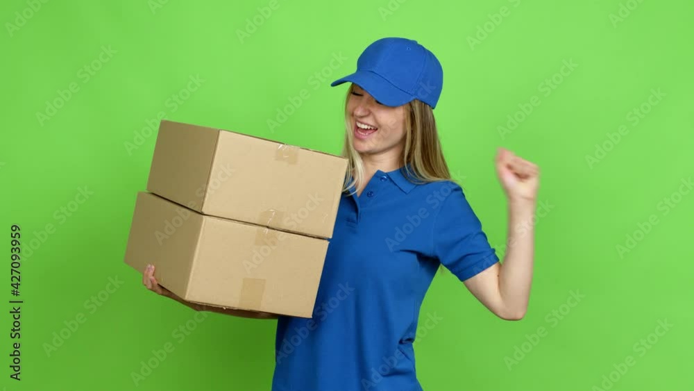 Young woman holding boxes for delivery celebrating a victory and ...