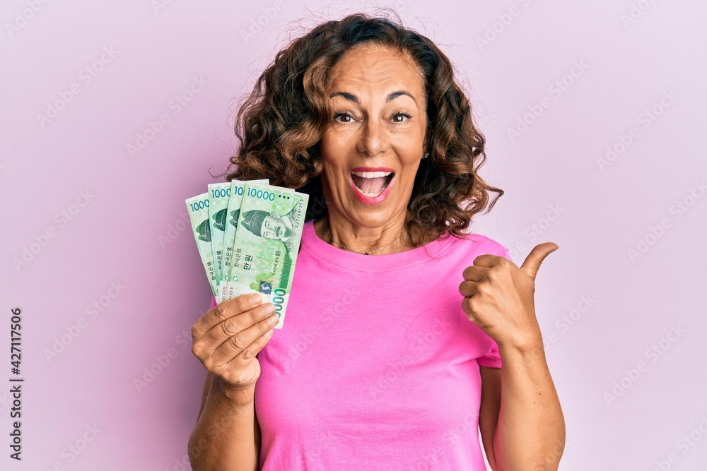 Middle age hispanic woman holding 10000 south korean won banknotes ...