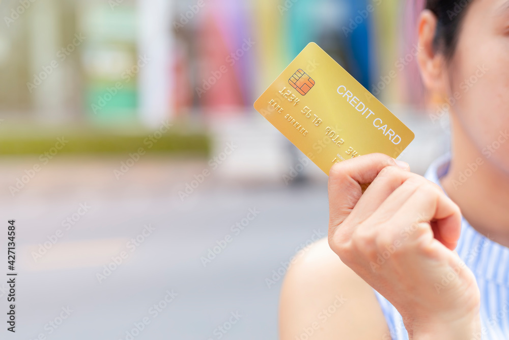 Women hand holding gold credit card member card over blur department ...