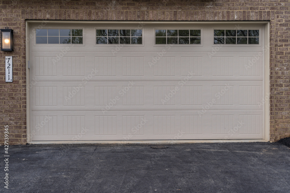 Beige double car garage door with brick facade on a new town house ...
