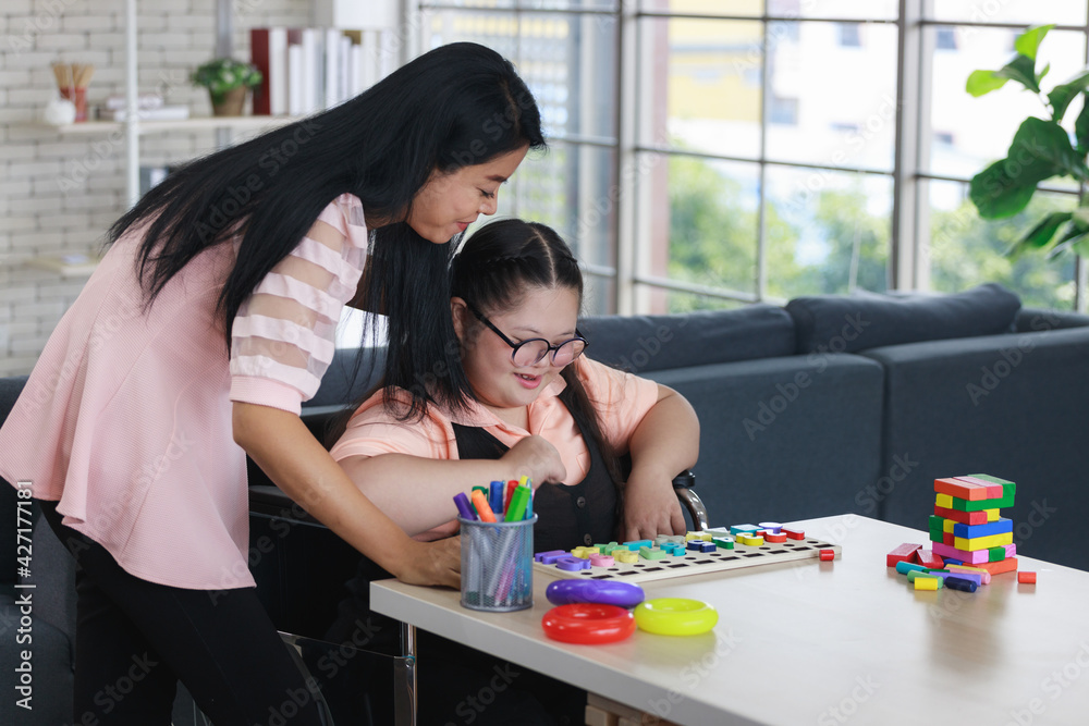 young girl with autism is practicing fun playing with toys at home with ...