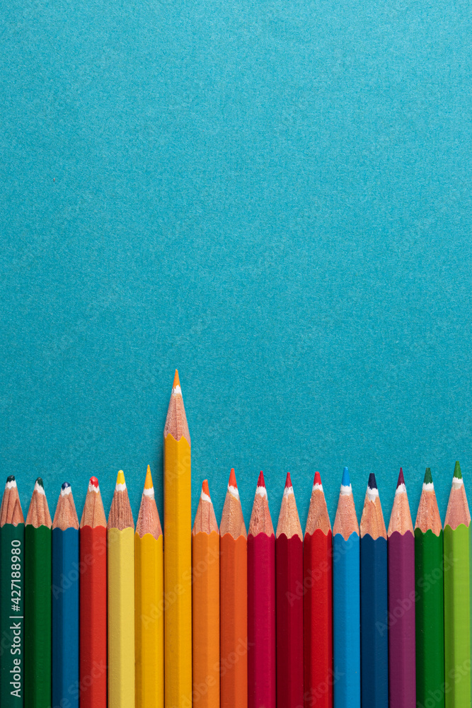 Top view. Colored pencils side by side on a blue background with ...