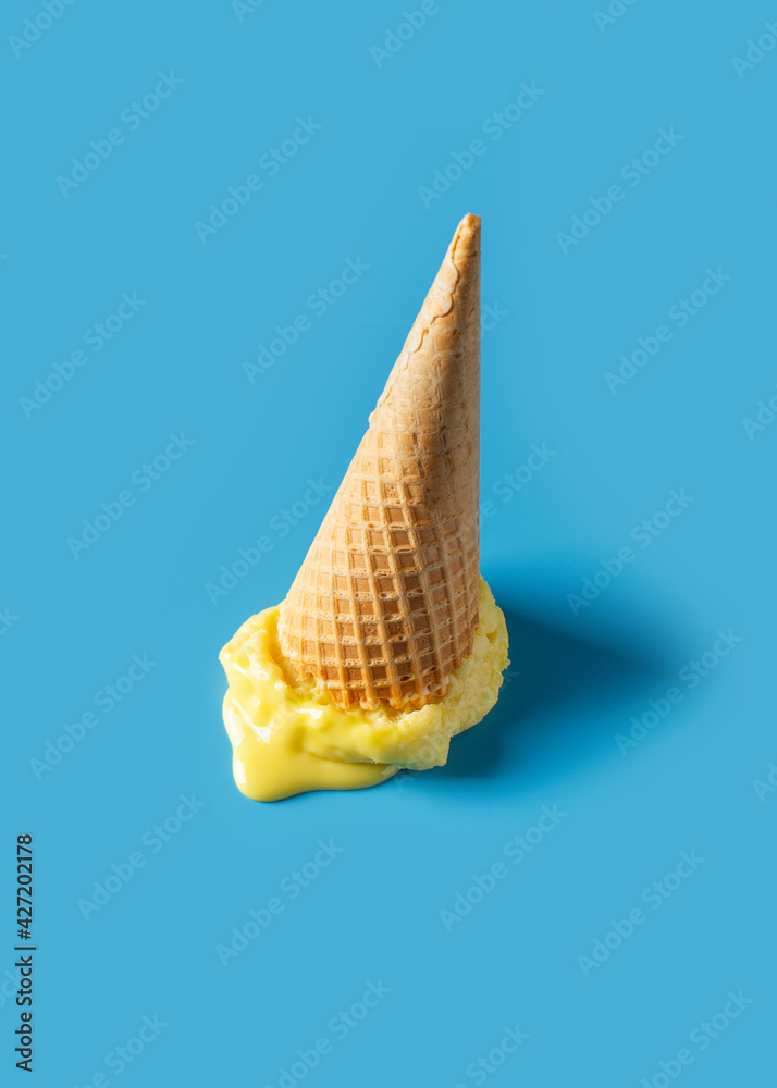 Melted yellow ice cream cone creative pastel blue background Stock ...
