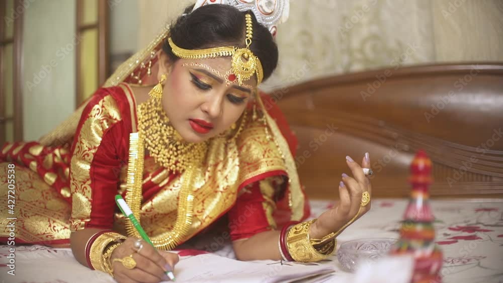Sad young Indian bride smoking cigarette and writing suicide note at ...