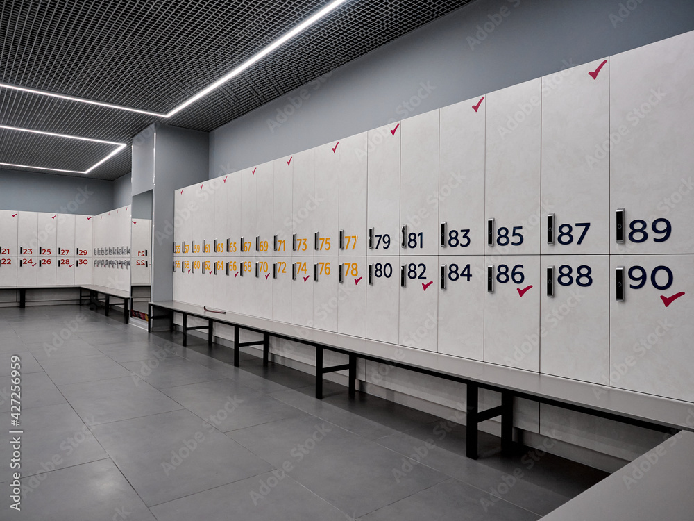 Modern dressing room in the gym. Two levels of lockers with electronic ...