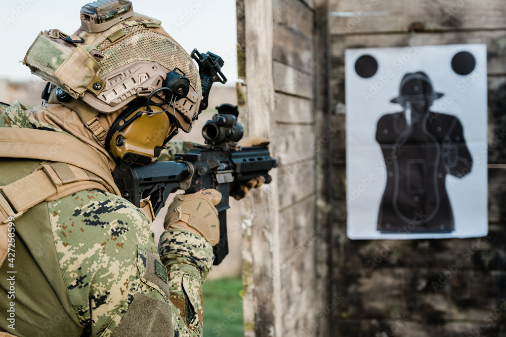 Soldier in the uniform (Cropat woodland pattern) taking aim at the ...