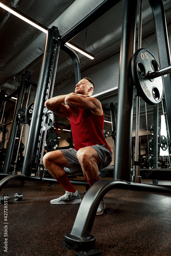 Closeup portrait of a muscular man workout with barbell at gym. Brutal ...