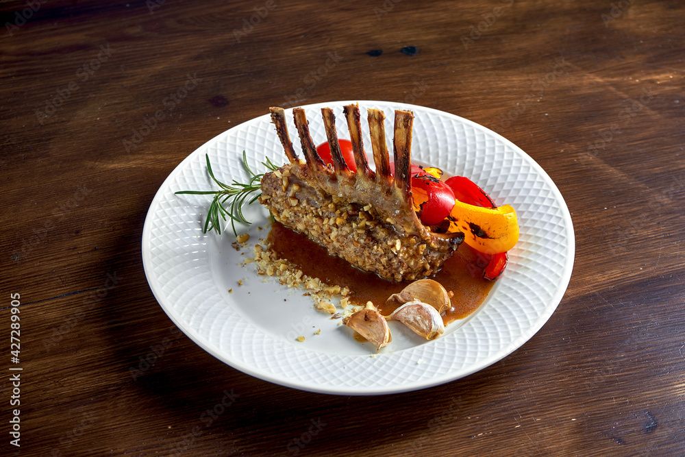 Appetizing roasted rack of lamb in nuts, with sauce and grilled ...